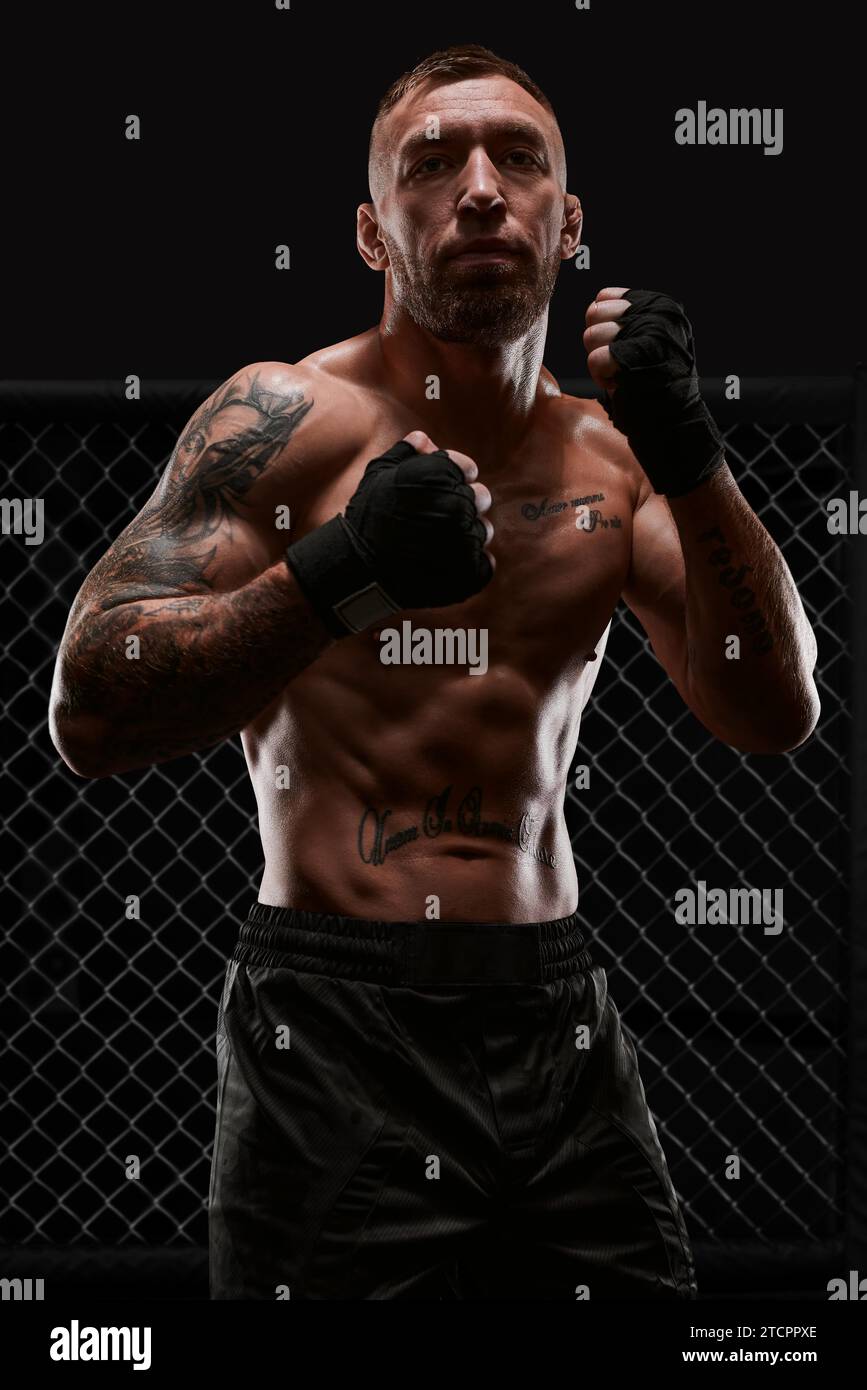 Conceptual image of a kickboxer. A real fighter stands in the real cage ...