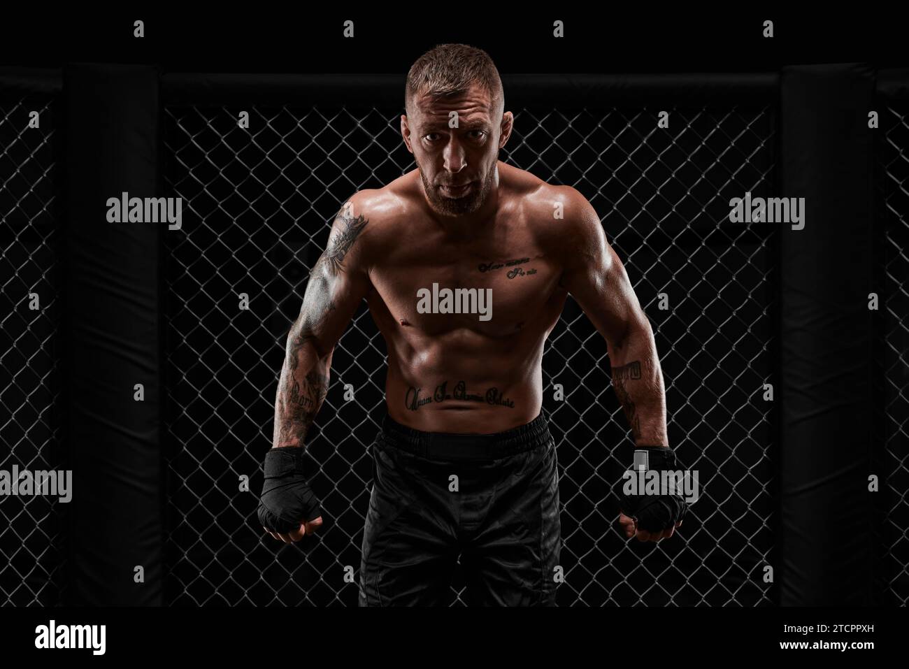 Conceptual image of a kickboxer. A real fighter stands in the real cage ...