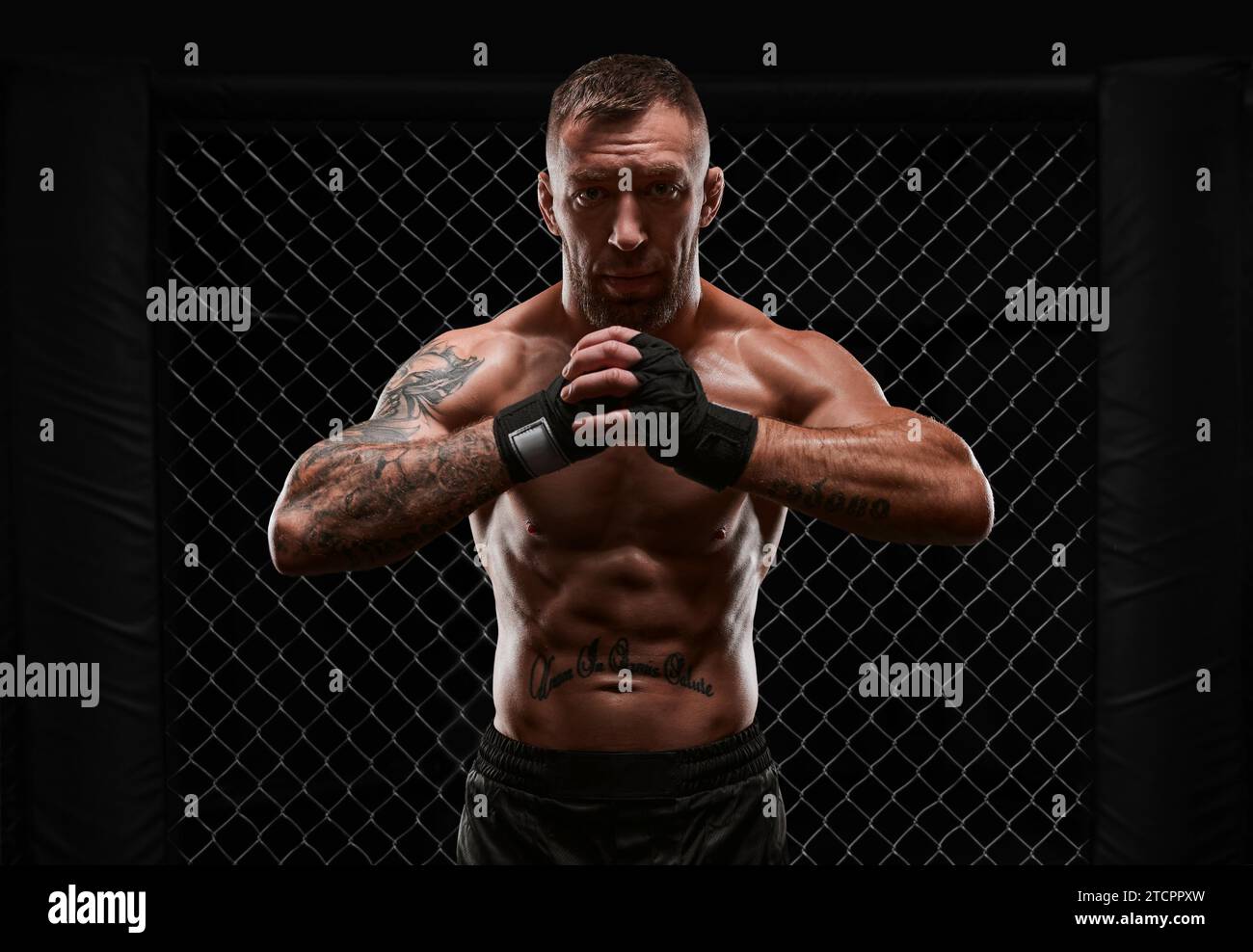 Conceptual image of a kickboxer. A real fighter stands in the real cage ...