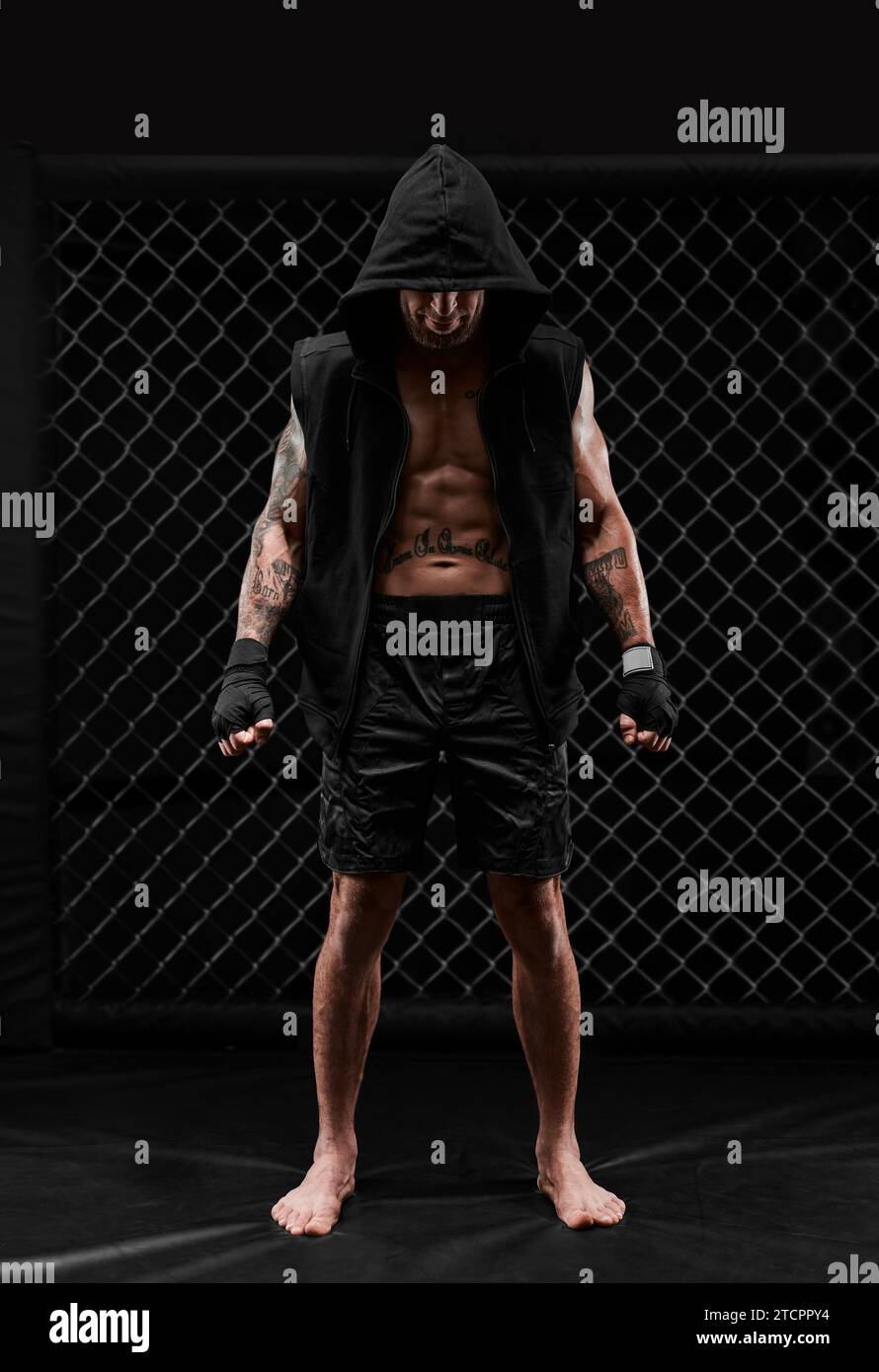 Conceptual image of a kickboxer. A real fighter stands in the real cage ...