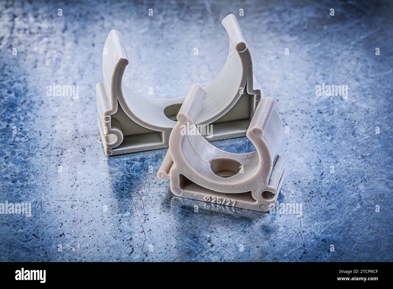 Water Plastic pipe clamps on metallic surface directly above the ...