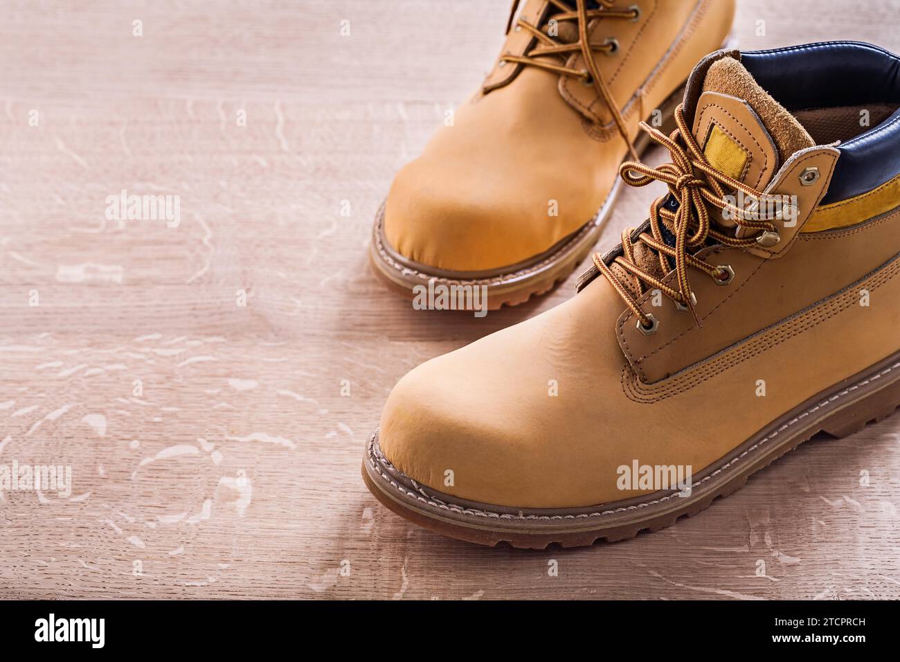 Horizontal view very close up View of two work shoes on wooden board ...