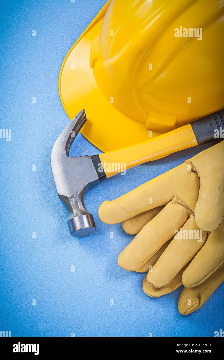 Claw hammer safety gloves hard hat on blue background vertical image ...