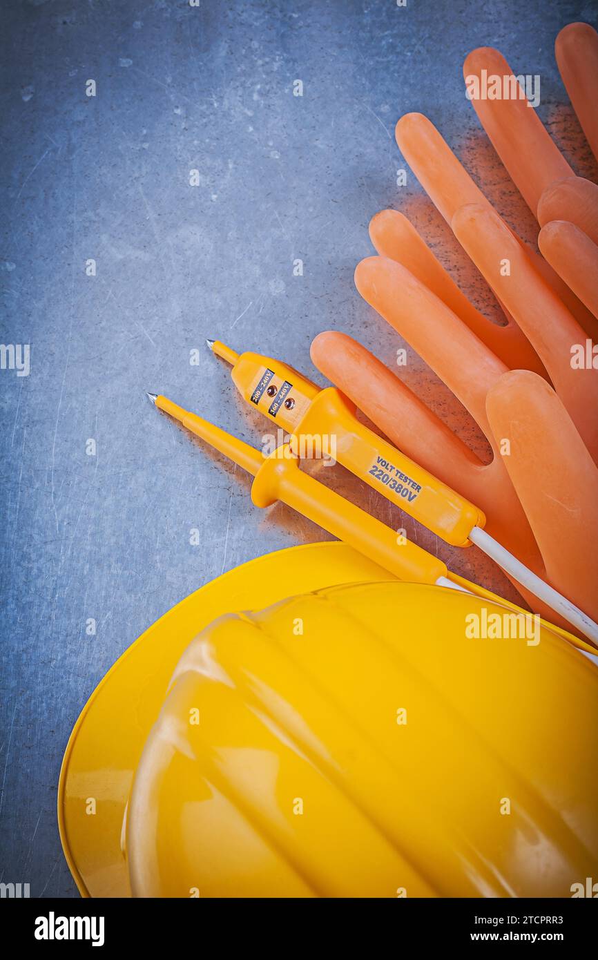 Insulating gloves Construction helmet Electrical tester on metallic ...
