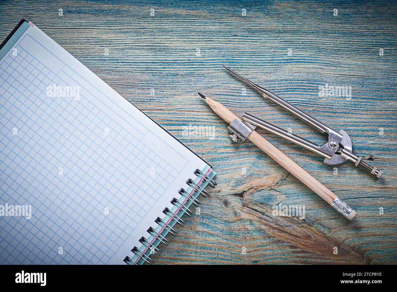 Vintage pair of compasses pencil checked copybook on wooden board ...