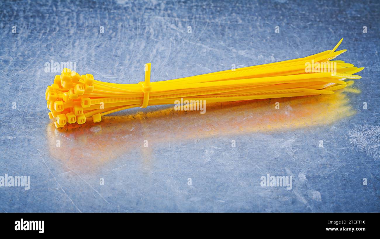 Yellow self-locking plastic cable ties on a metallic background Design ...