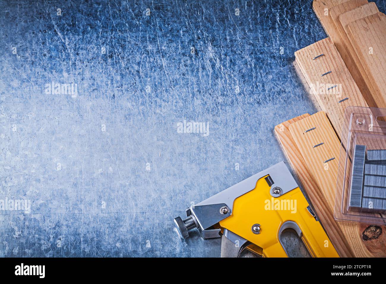 Yellow stapler staple gun metal staples wooden boards on metallic ...