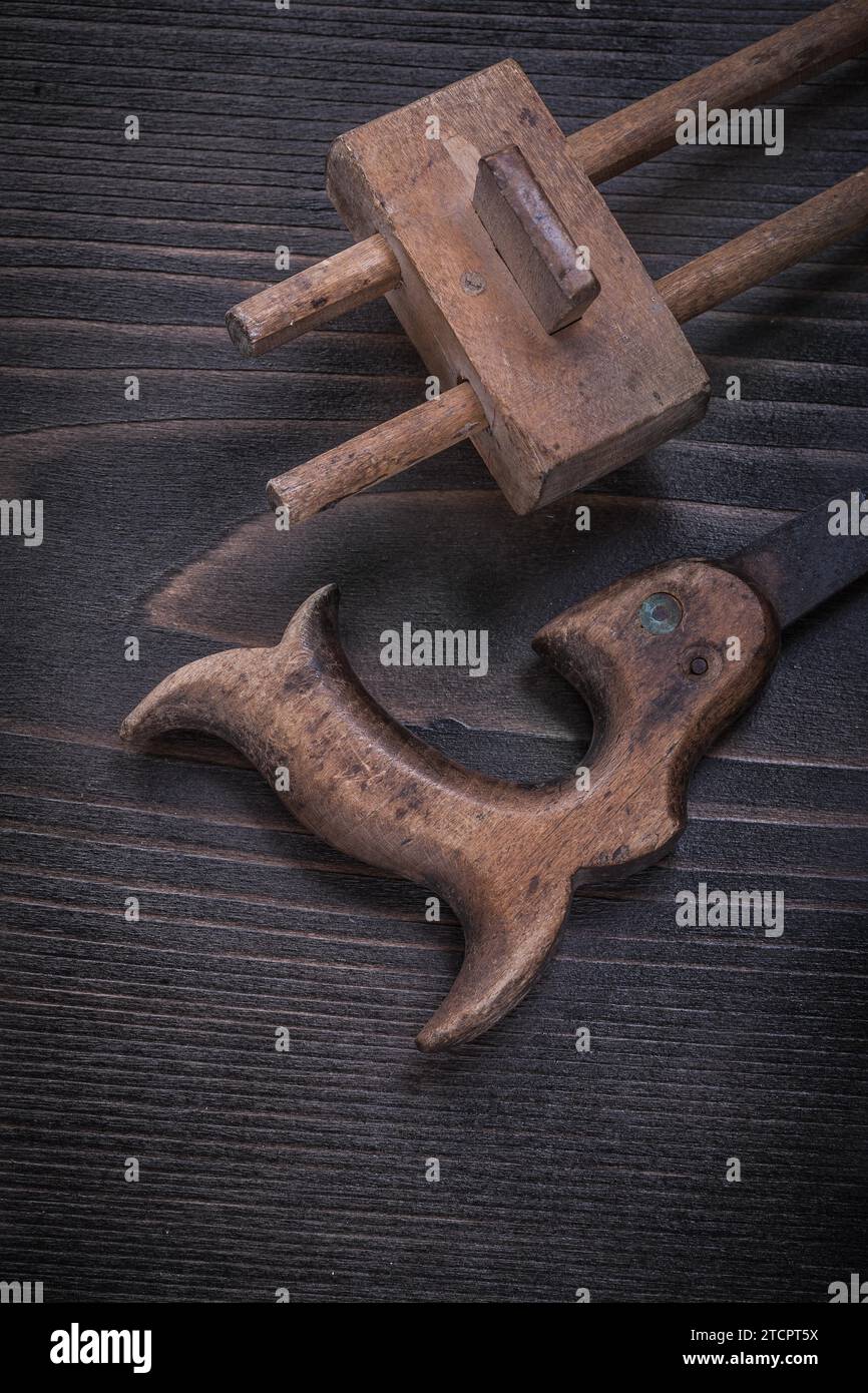 Ancient rusty hand saw with wood marking gauges on wooden board Stock ...