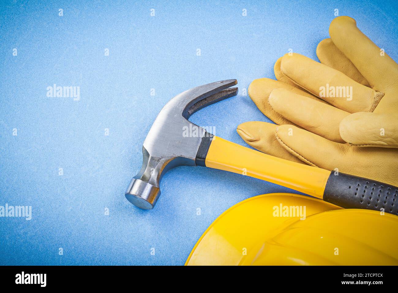 Claw hammer Protective gloves Construction helmet on blue background ...