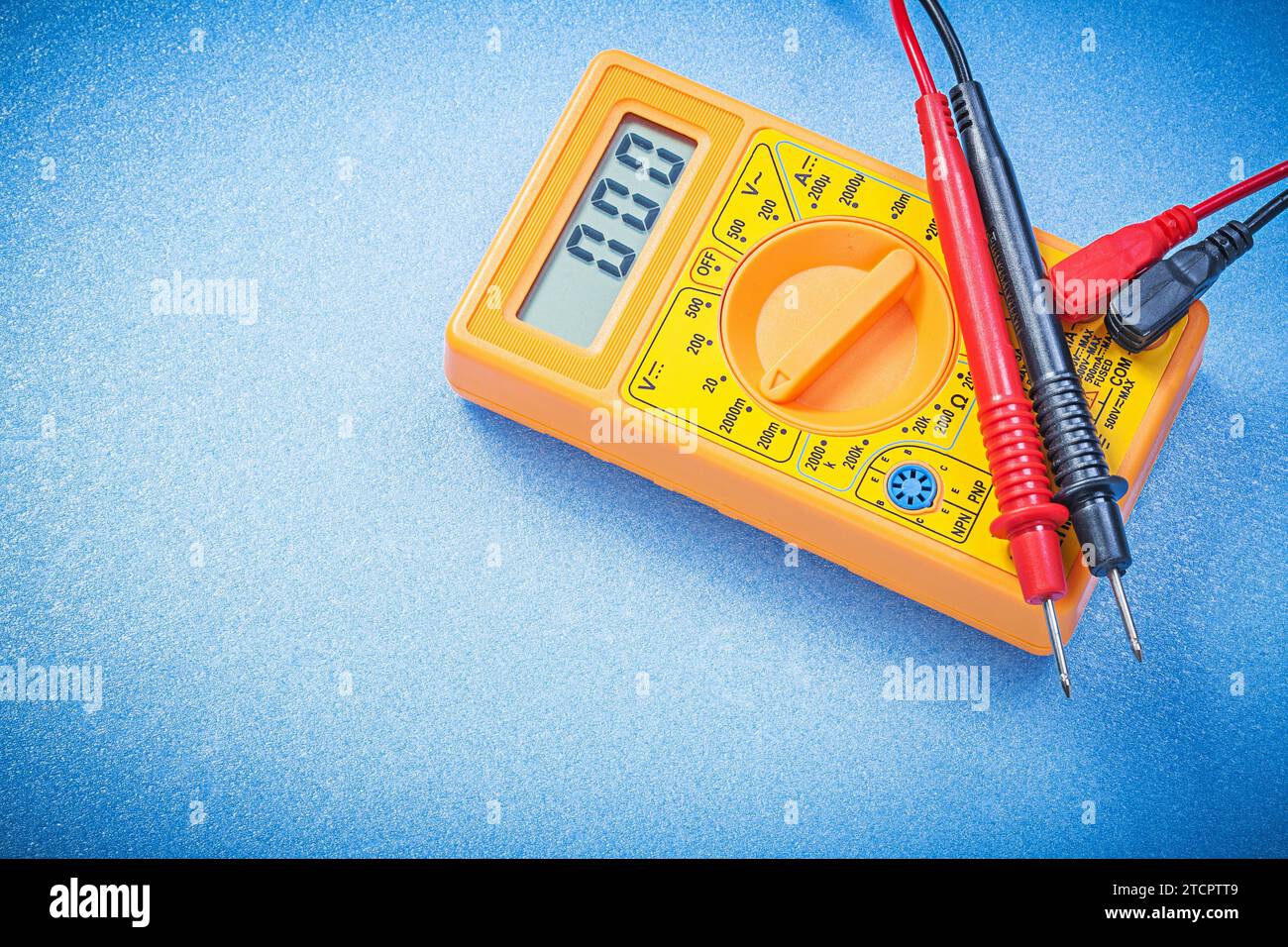 Electrical digital multimeter on a blue background directly above the ...