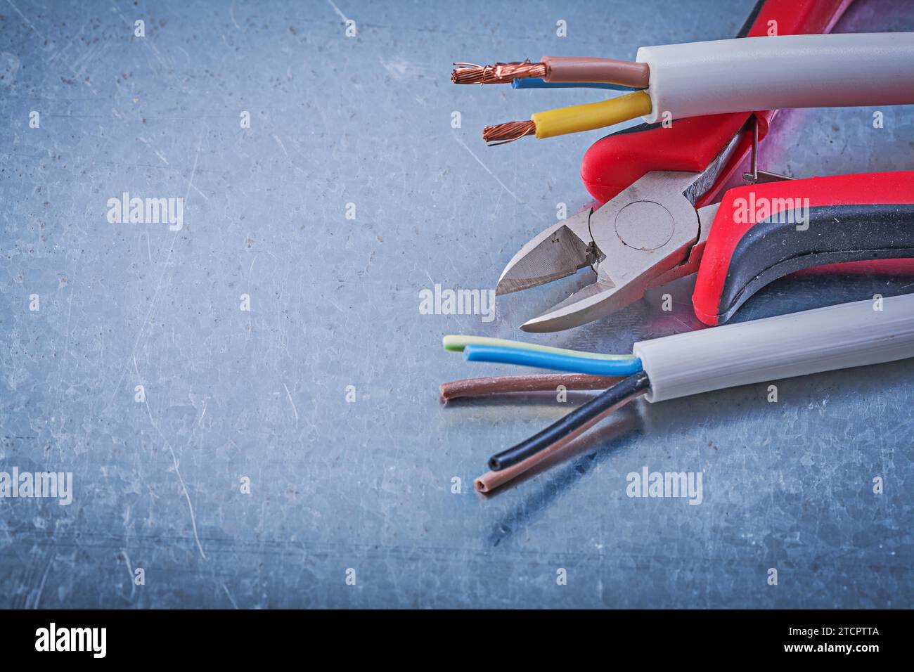 Electrical cable wires pliers on scratched metallic background ...