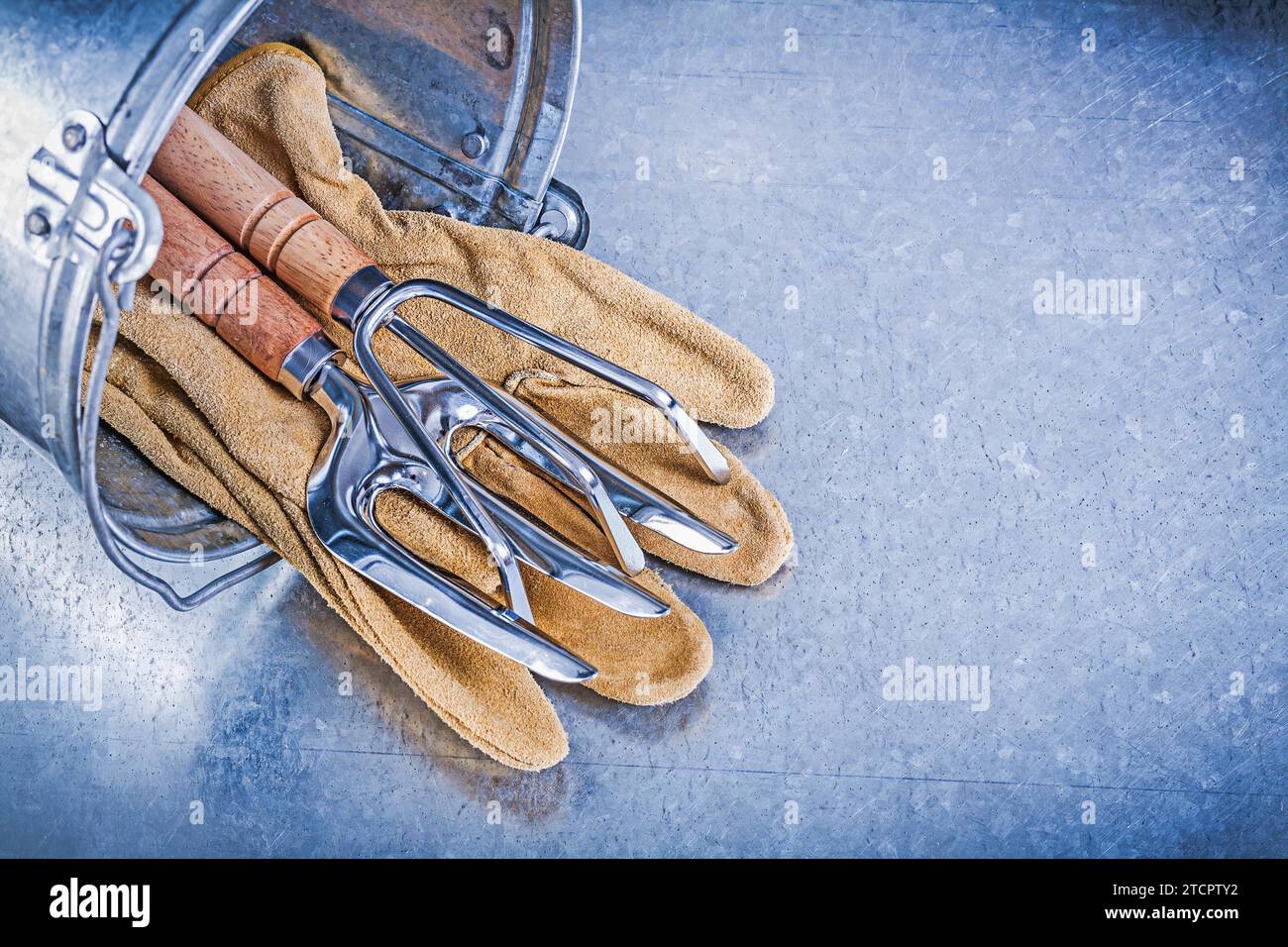 Galvanised bucket metal rake trowel fork leather protective gloves on ...