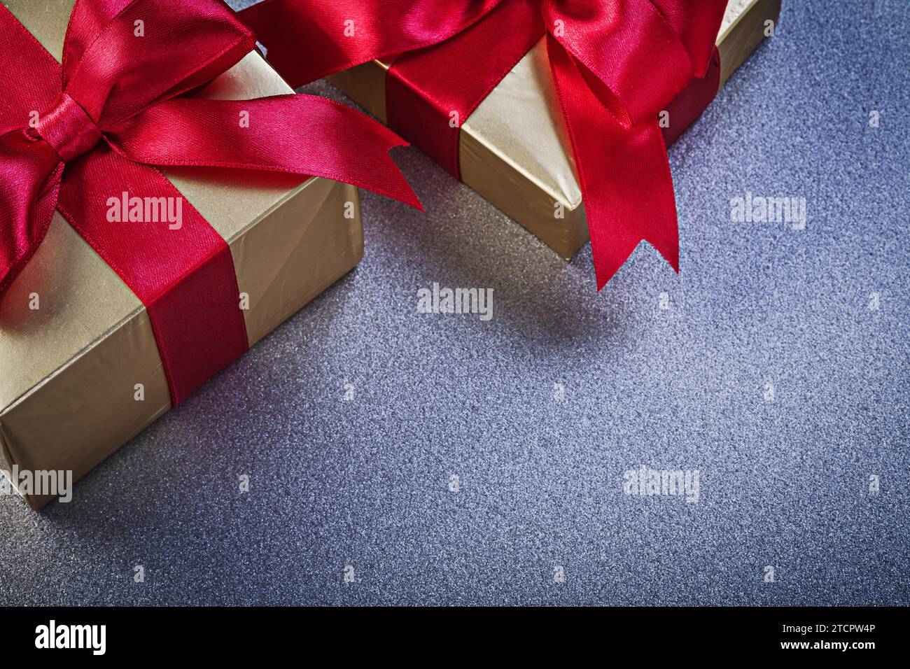 Gift boxes with red knots on a grey background Holiday concept Stock ...