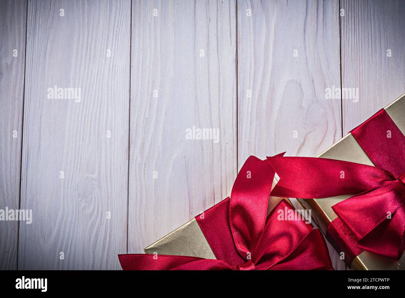 Wrapped gift boxes with knots tied on wooden board Holiday concept ...