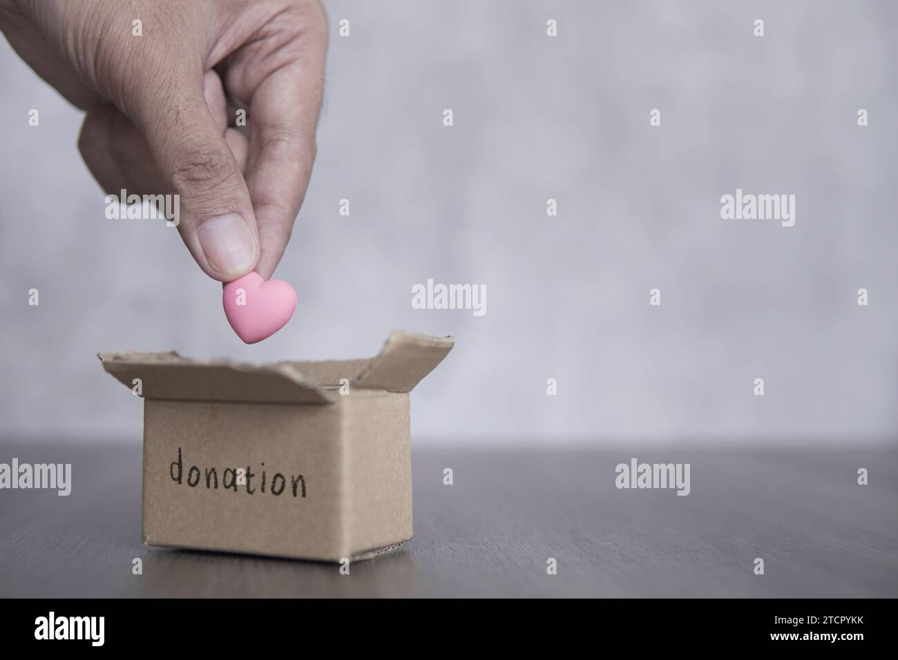 Hand putting heart into donation box. Copy space for text. Organ ...