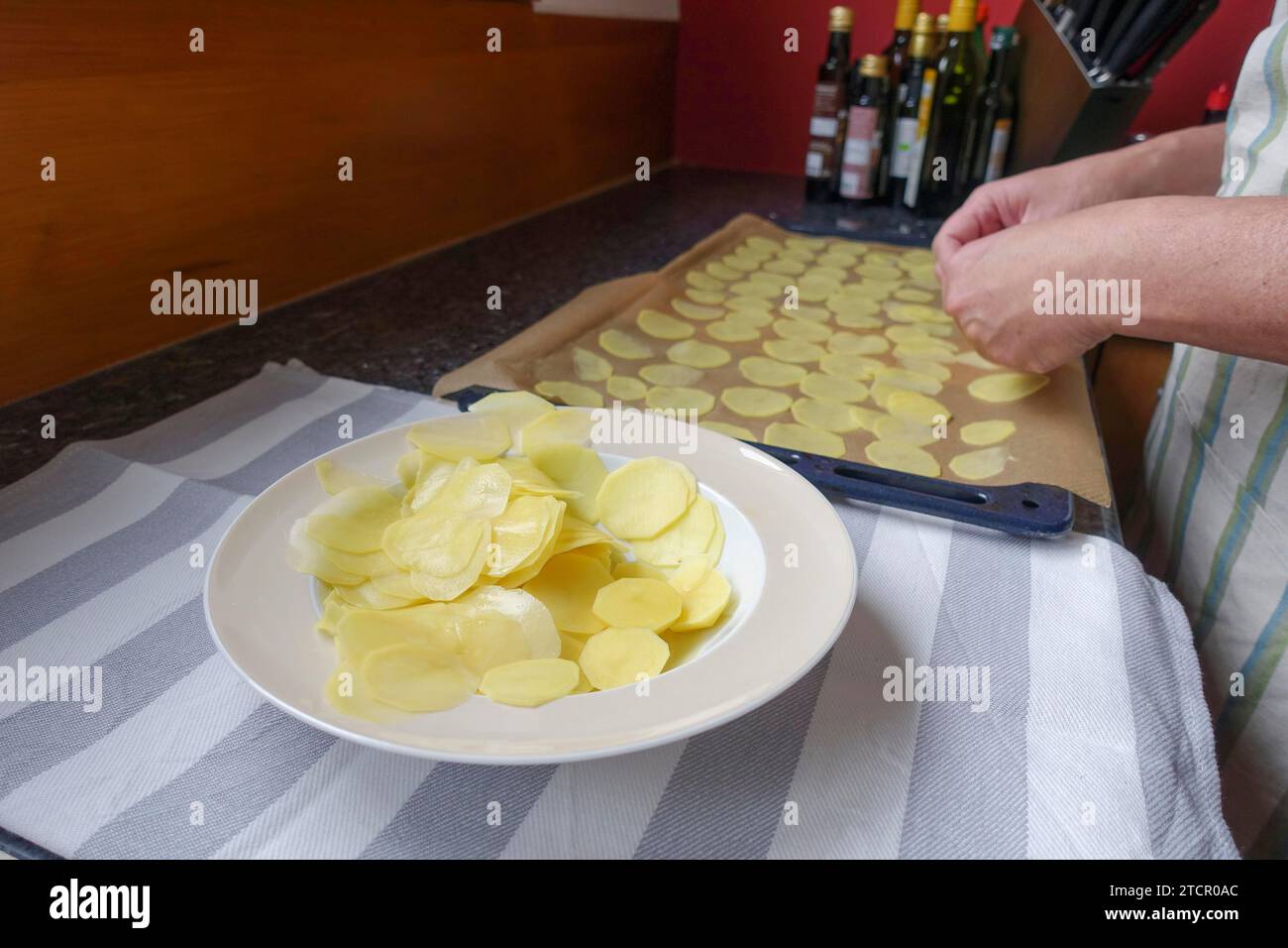 Preparation of cress soup with crisps, potato wheels on baking tray ...