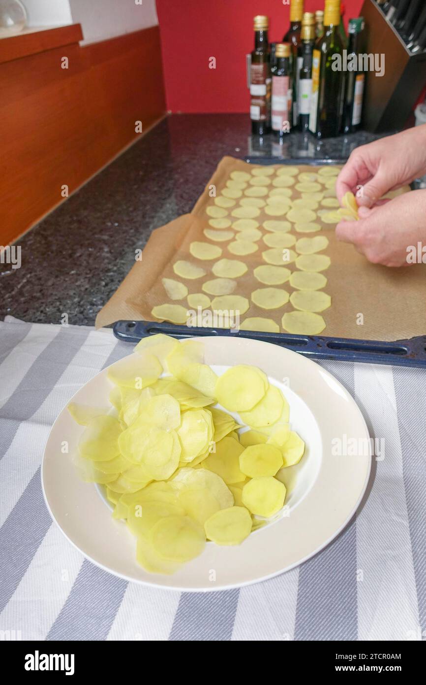 Preparation of cress soup with crisps, potato wheels on baking tray ...