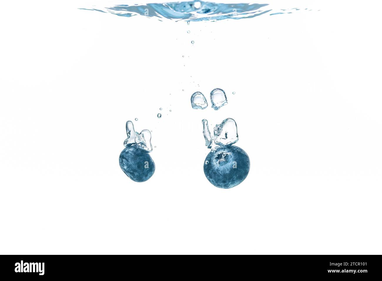 Two blueberry?s splashing into crystal clear water Stock Photo - Alamy