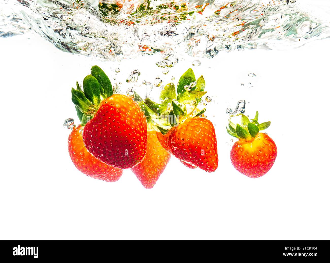 Strawberries falling into water causing bubbles all around it. Healthy ...