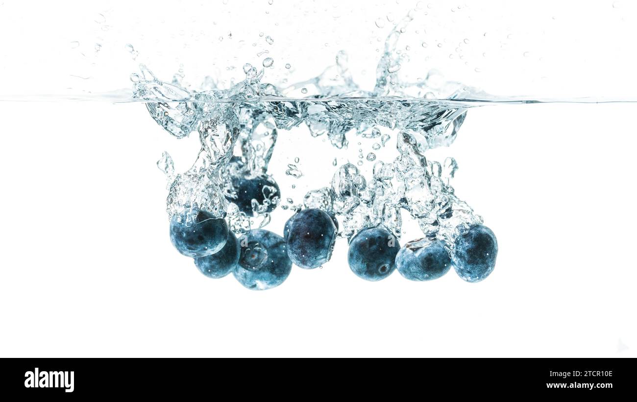 Fresh blueberries falling in water on white background. Fruits ...