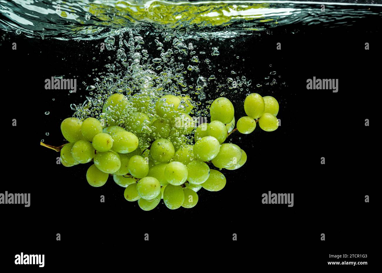 Bunch of white grapes sinking underwater with splash isolated on black ...