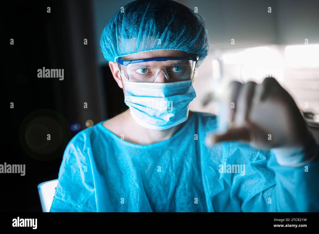 Young male surgeon doctor in uniform with a syringe is preparing for ...