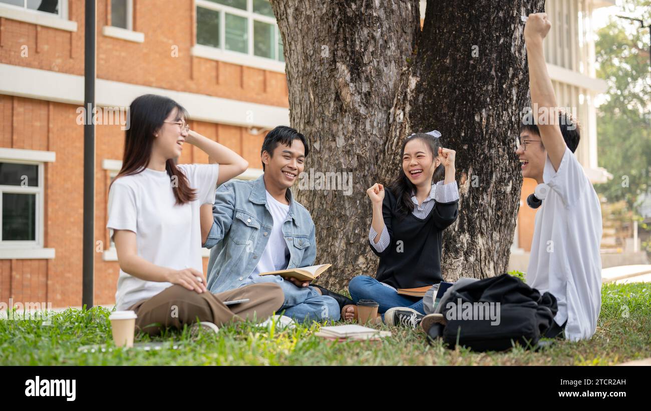 A group of cheerful young Asian students are celebrating their good ...