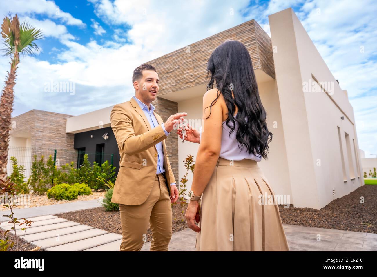 Woman receiving the keys of a new house outside the building Stock ...