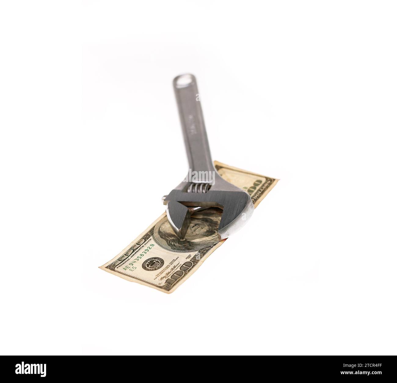 Wrench tool fixing dollar bill isolated on white background closeup ...