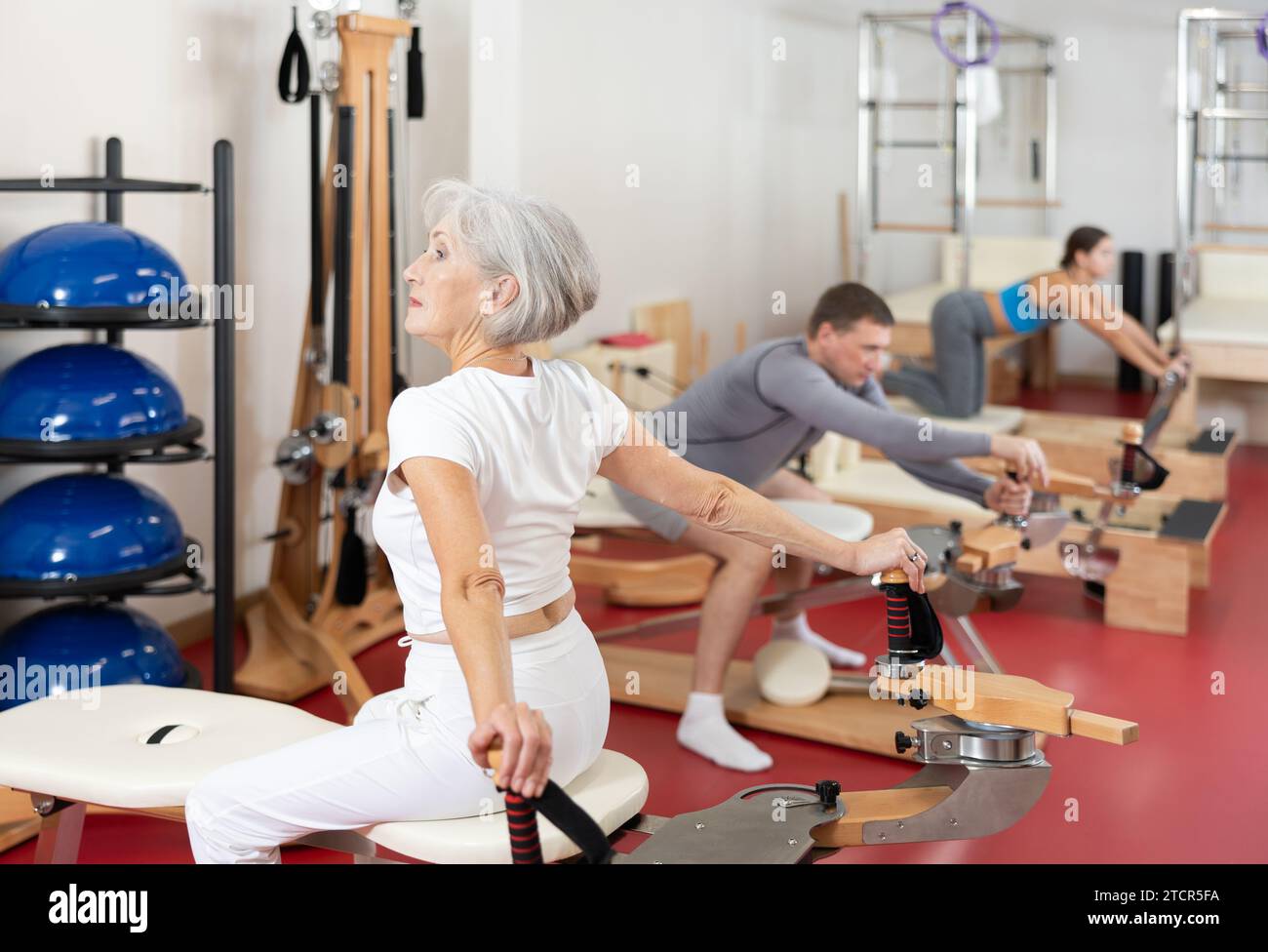 Senior woman performs Pilates exercises for weight loss and toning ...
