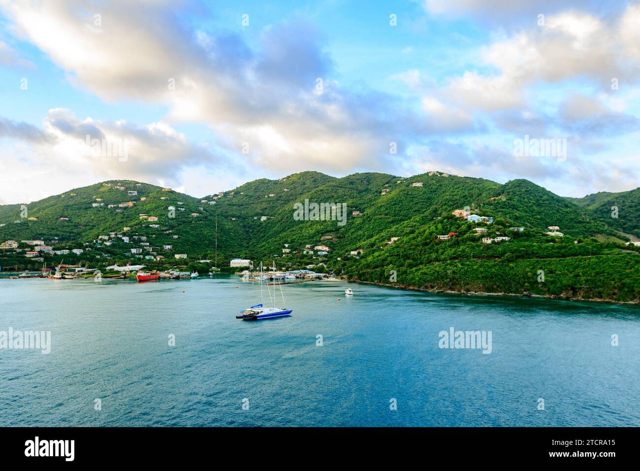 A picturesque body of water surrounded by a cloudy sky, featuring a ...