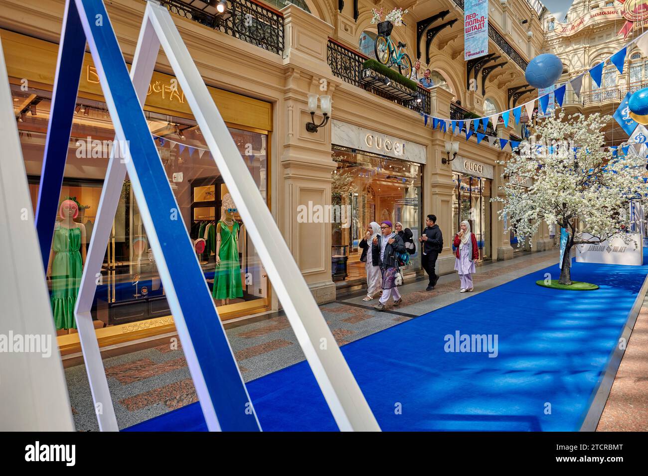 Muslim tourists eating Plombir ice cream walk together in GUM ...