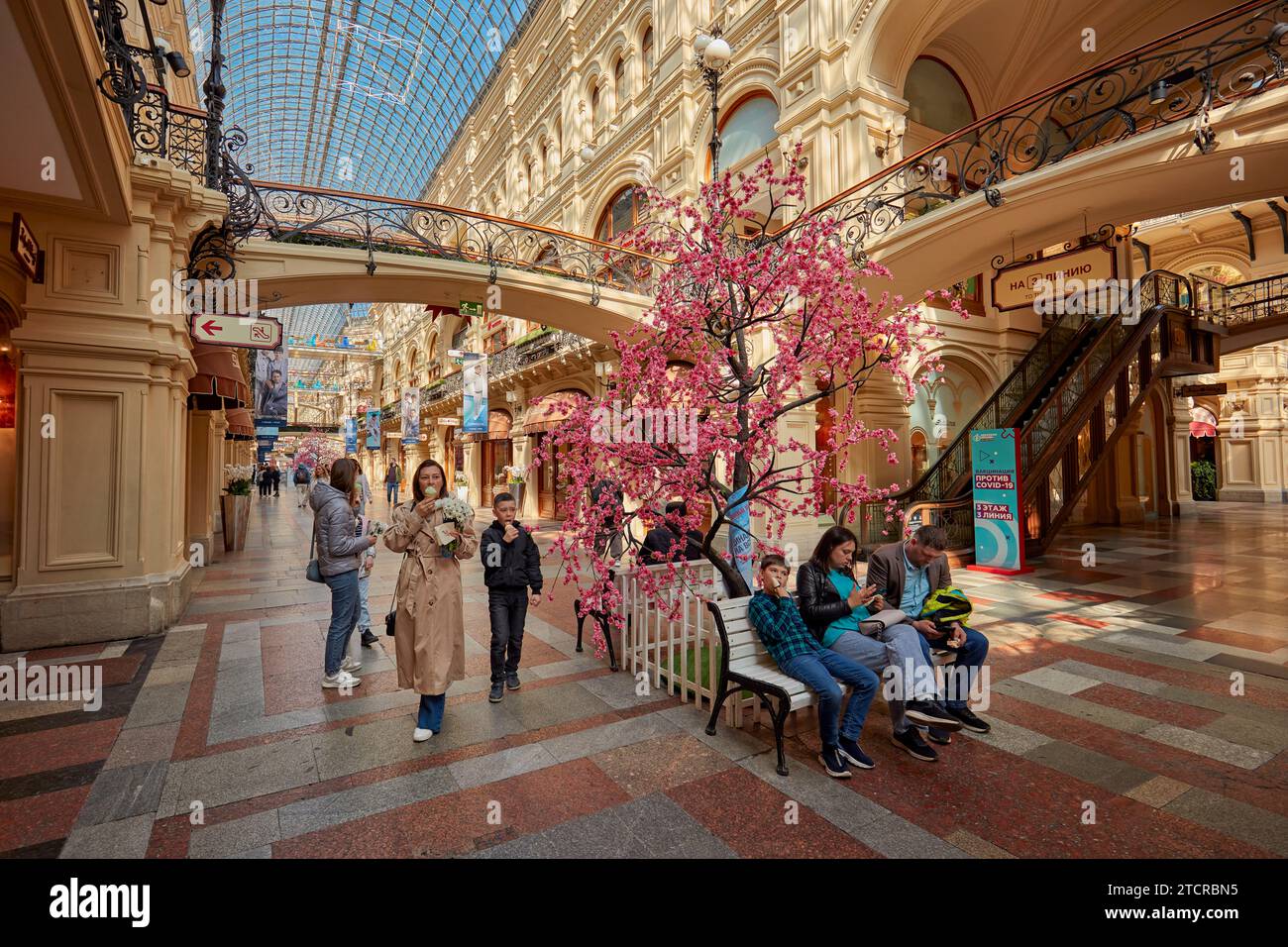 Mother and son eating Plombir ice cream walk together in GUM department ...