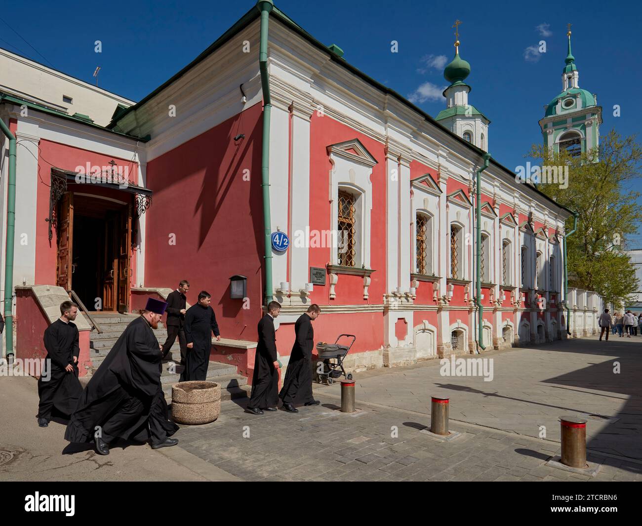 Men dressed in Orthodox black robes walk out of the Church of The ...