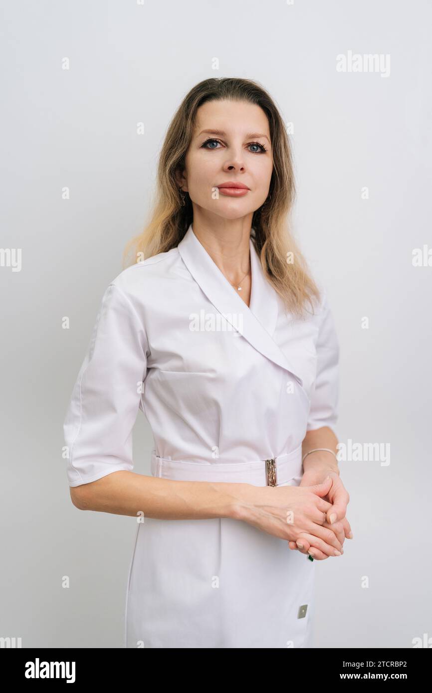 Vertical portrait of pretty female doctor wearing coat uniform standing ...