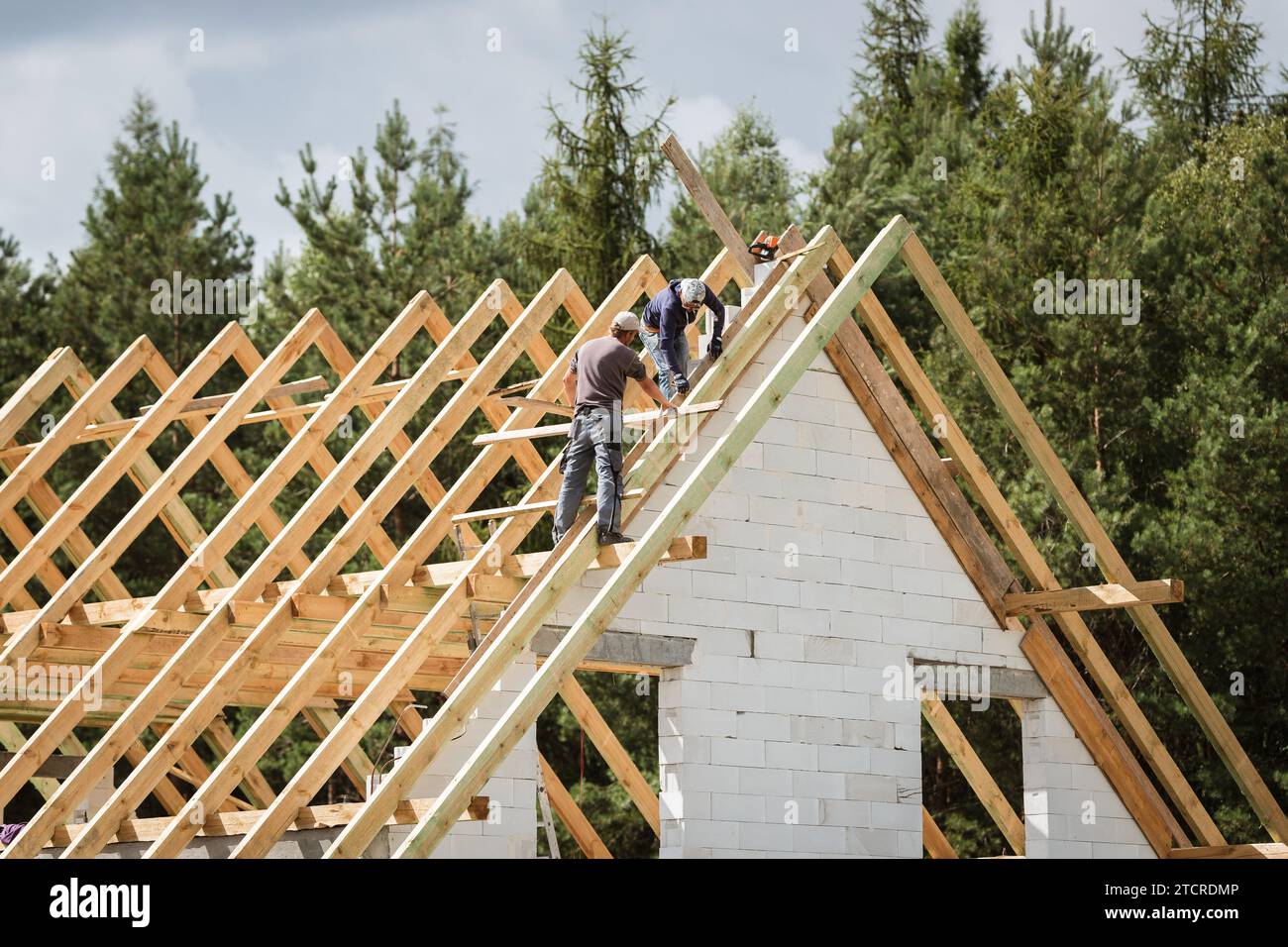 Two men work on the roof of house construction Stock Photo - Alamy