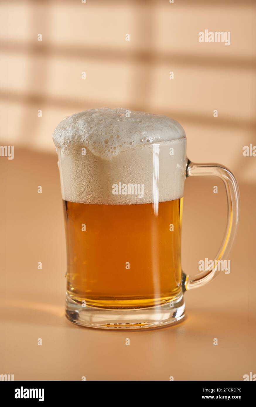 A pint of beer in various foam stages on beige background Stock Photo ...