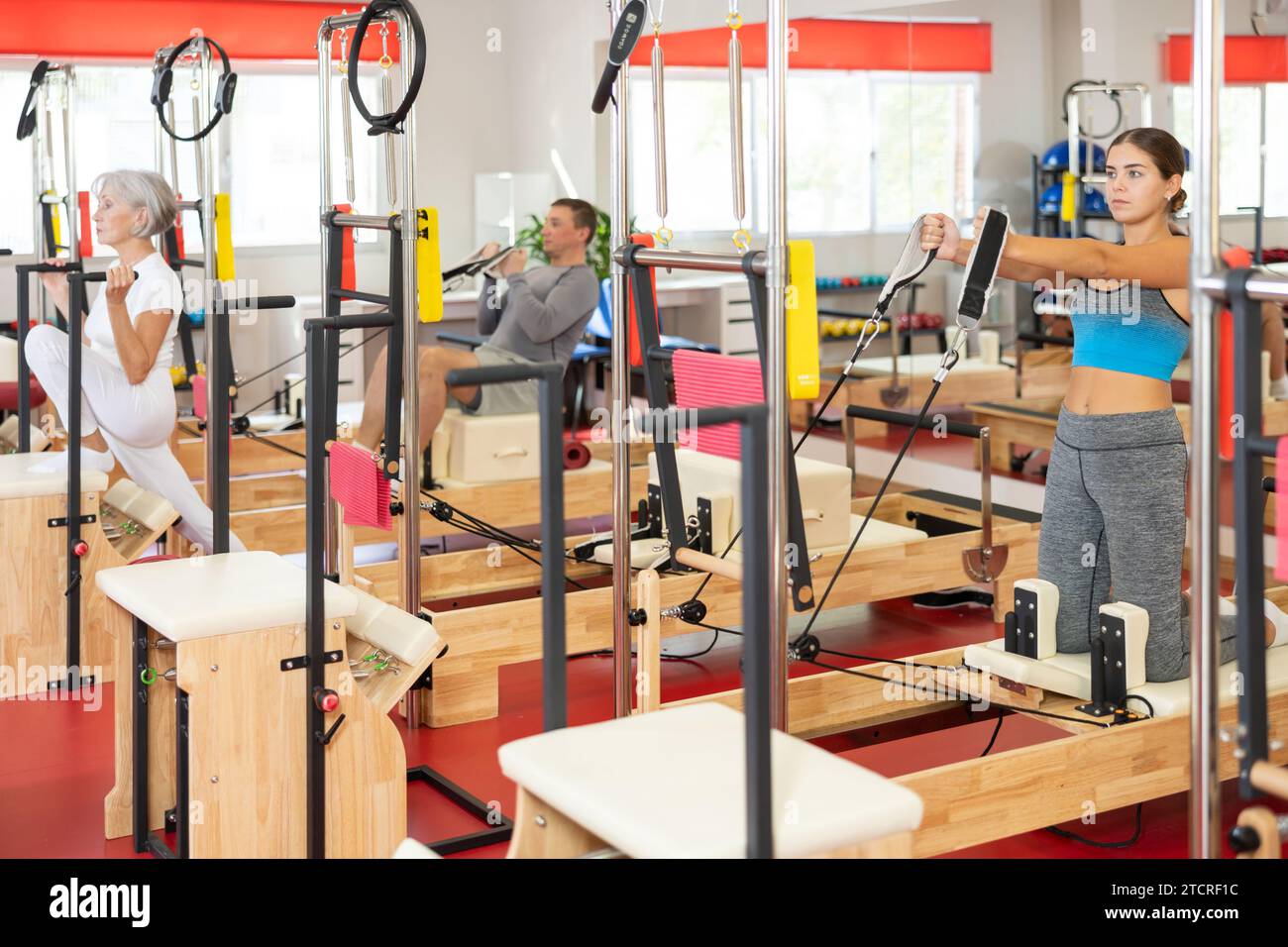 Sports club girl client on reformer with cable and rope performs ...