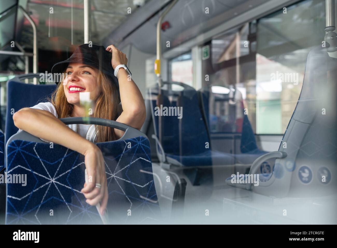Urban young woman smiles inside bus, embracing urban lifestyle. City ...