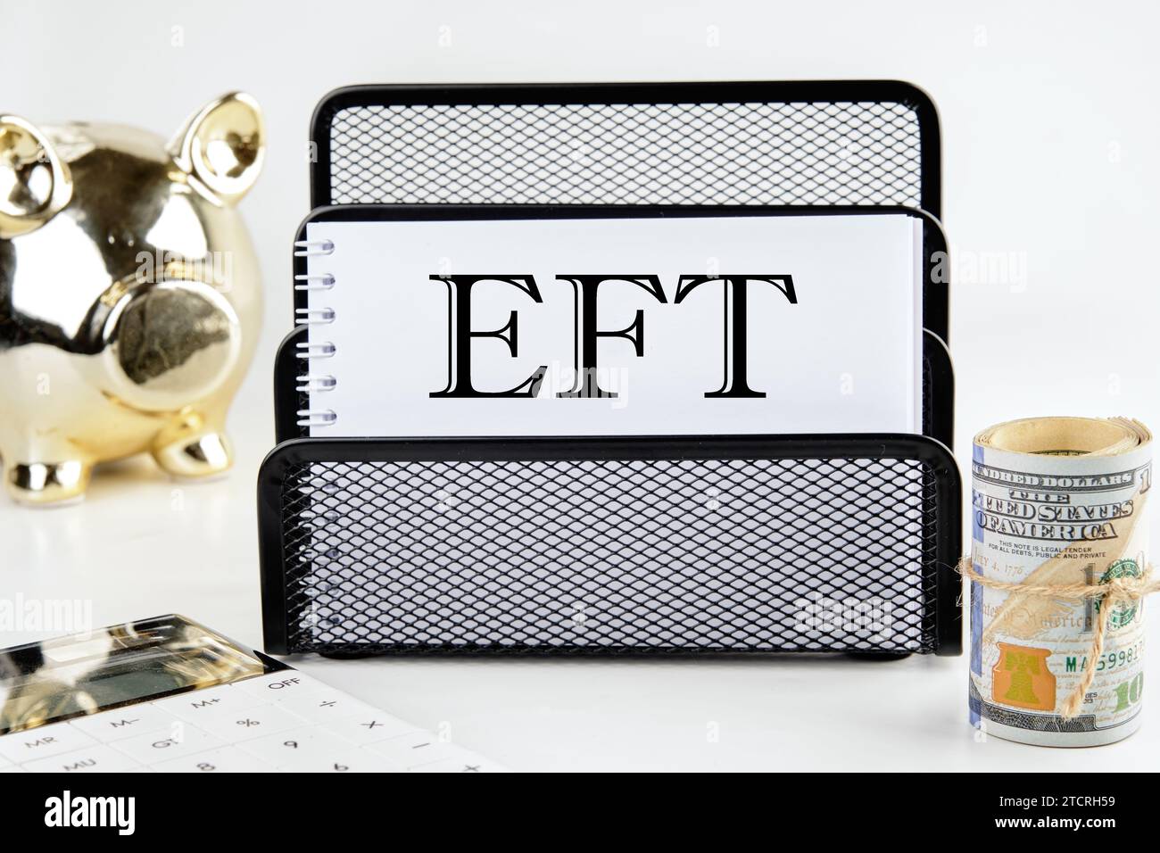 EFT text on a white piece of paper next to a piggy bank, a roll of ...