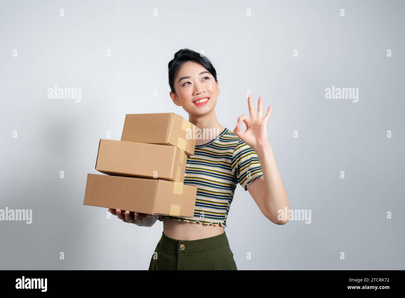 Portrait of young Asian business woman with boxes showing OK sign Stock ...