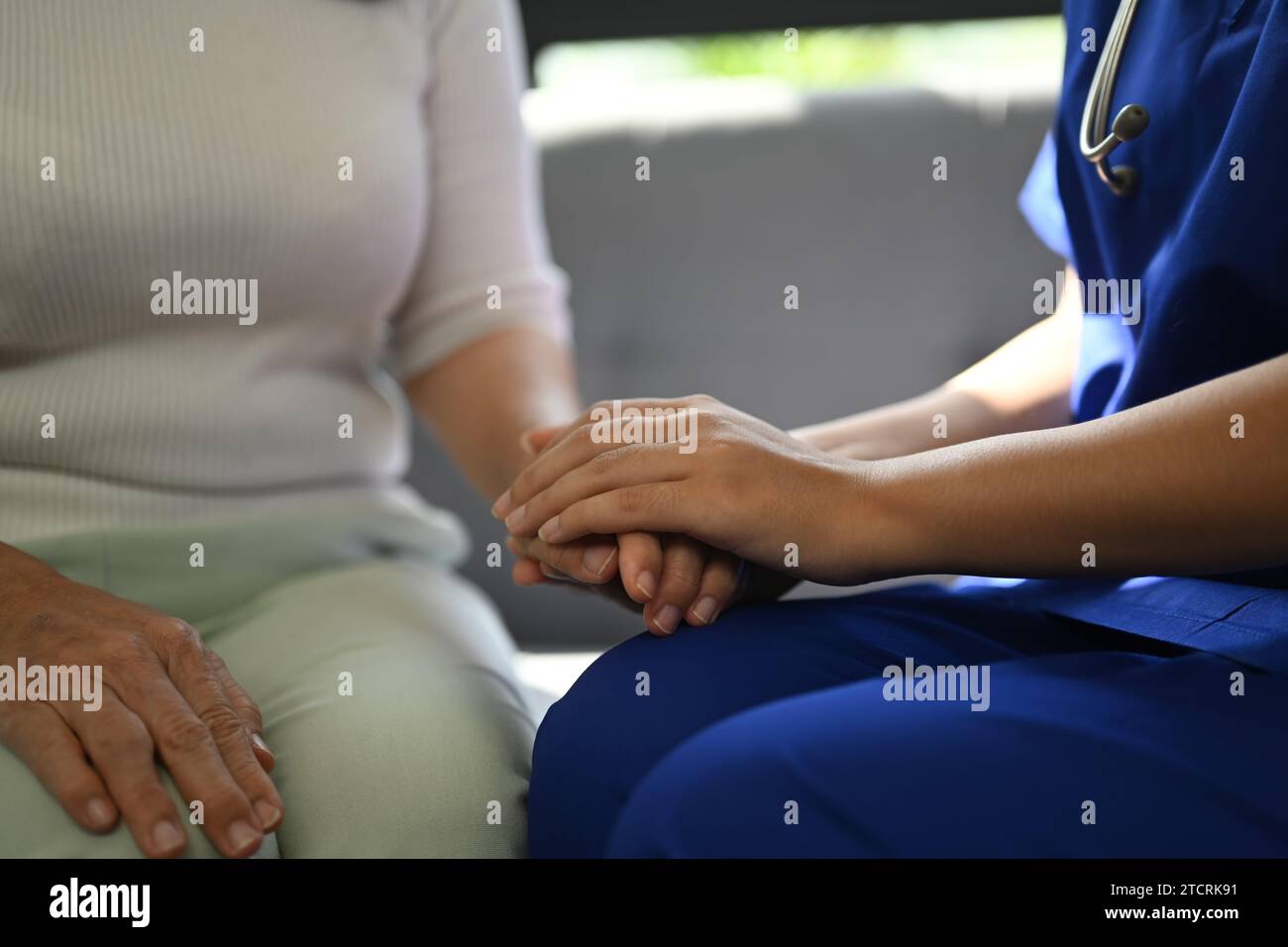 Female doctor holding hand of senior patient giving comfort, expressing ...