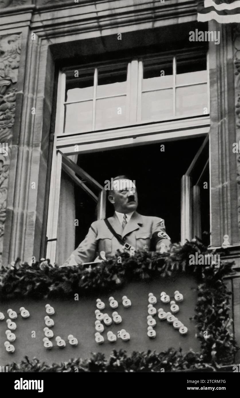 Adolf Hitler is seen peering from a window of the Hotel Deutscher Hof ...