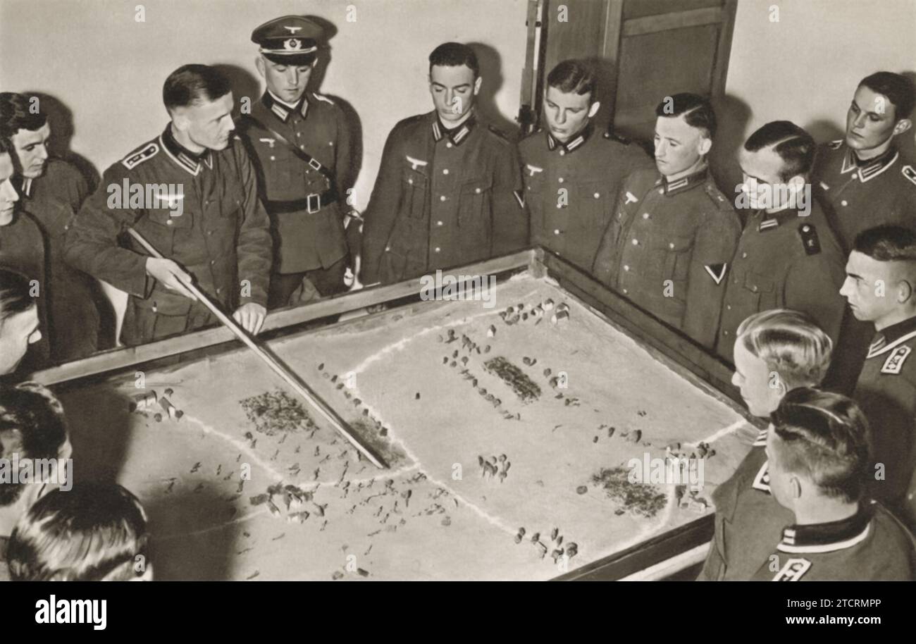German recruits are pictured gathered around a 'sand table,' a ...