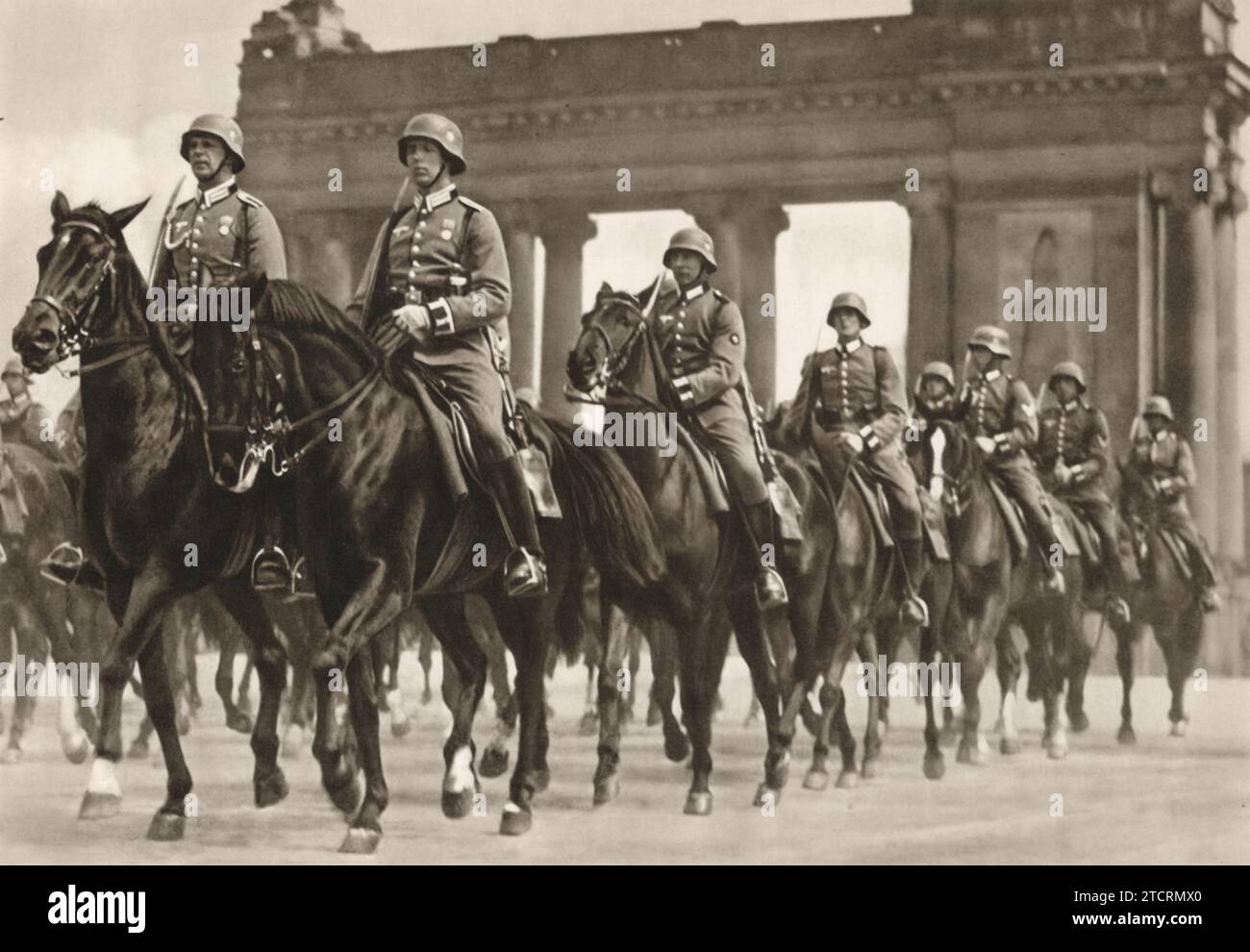 German soldiers on horseback parade before the Fuhrer (Adolf Hitler), a ...