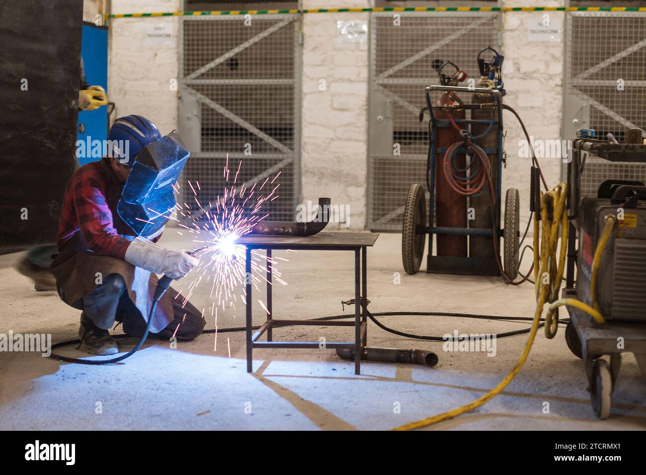Blue color worker welds the pipe in the workshop in copper mine Stock ...