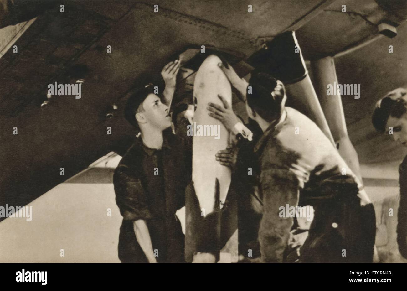 Practice bombs being attached to a German aircraft, part of a training ...