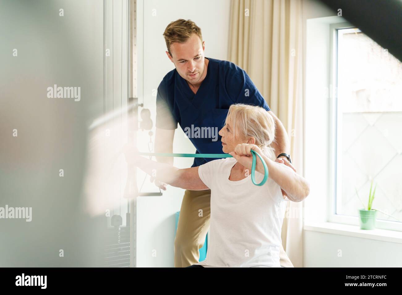 Senior woman performing arm-strengthening exercises with resistance ...
