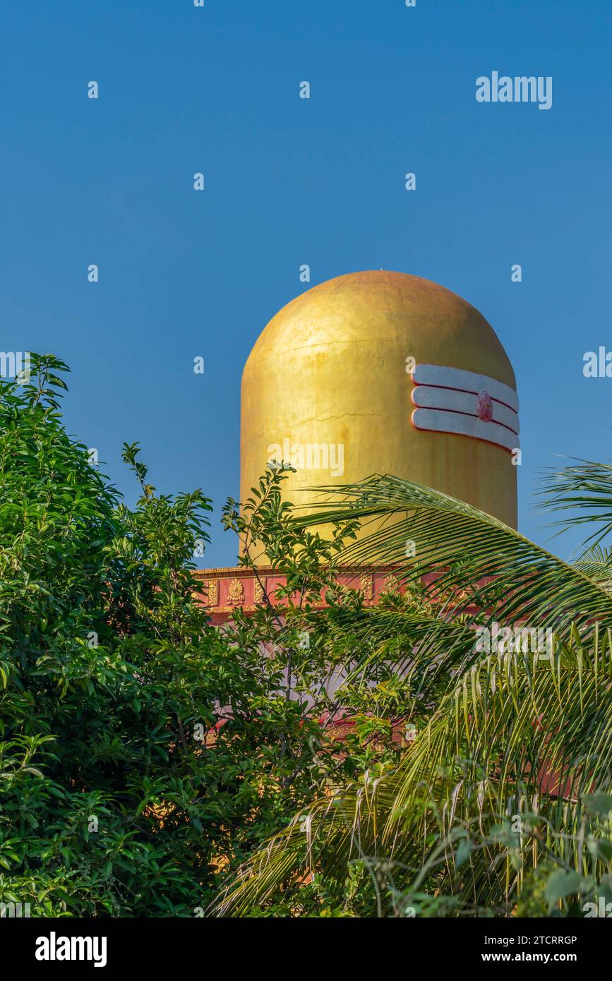 Top of a golden color Lord Shiva Lingam temple in Puttaparthi with ...