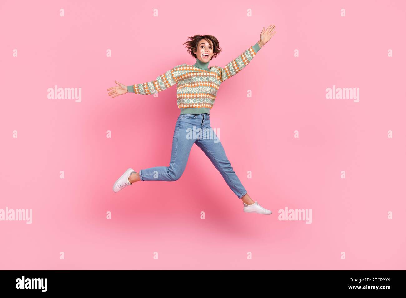 Full length cadre of charming young energetic funky woman jumping up ...